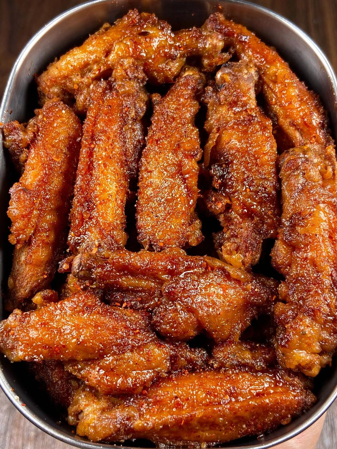 The crispy chicken wings are charred and fragrant, and coated with a ...
